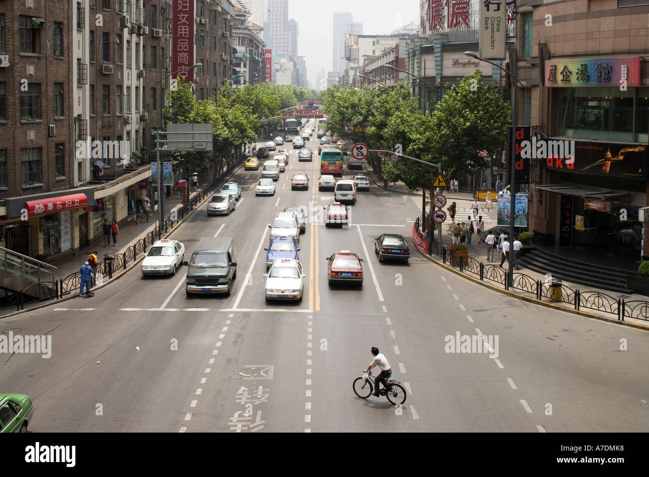 Asia China Shanghai Bicyclist rides through busy intersection near Yan ...