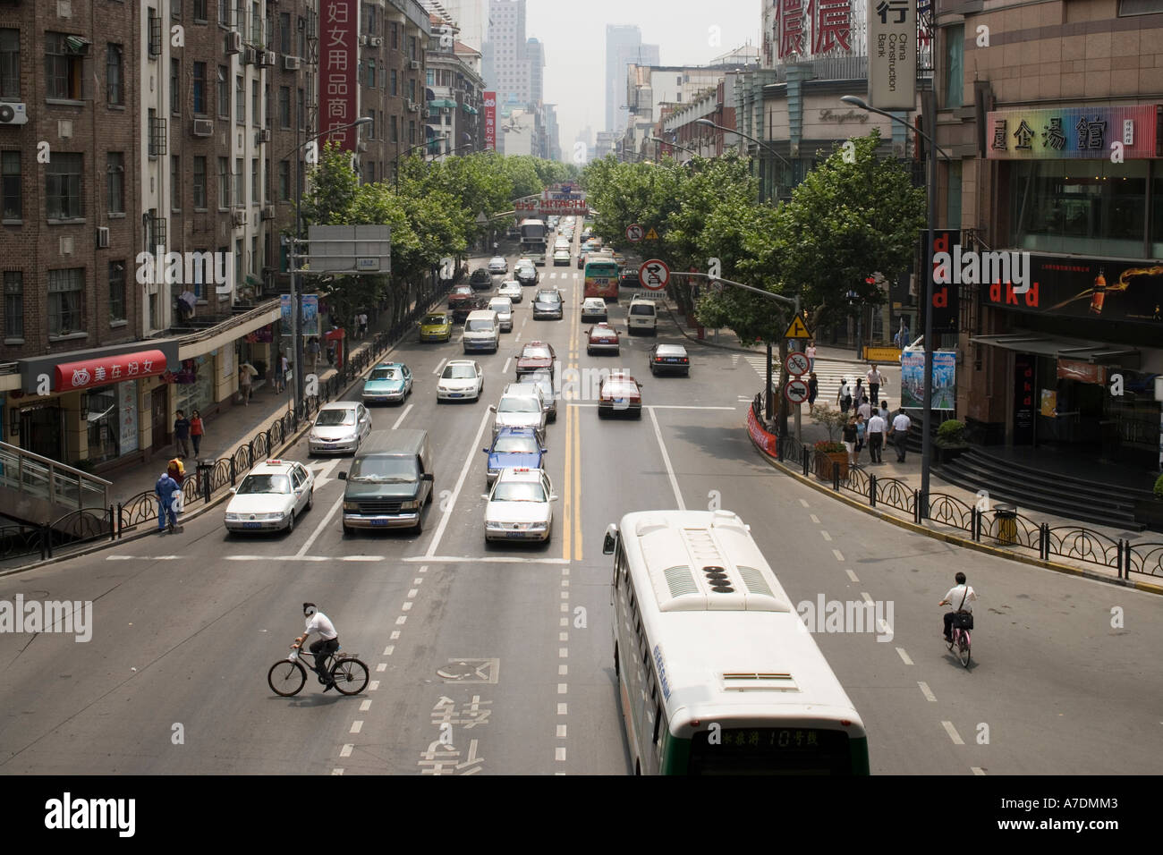 Asia China Shanghai Bicyclist rides through busy intersection near Yan ...