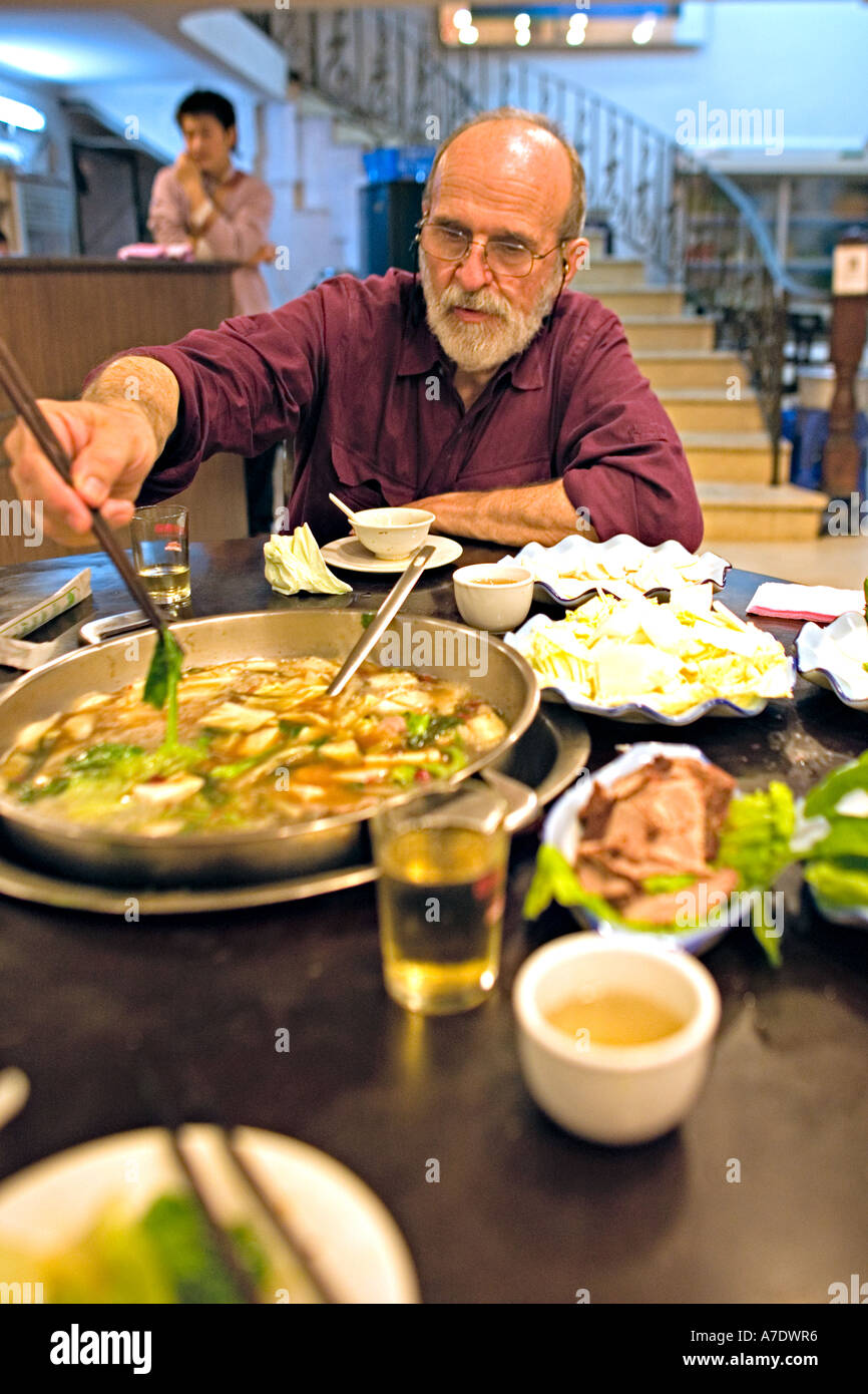 CHINA WUHAN Western tourist enjoying Mongolian hotpot meal with a ...