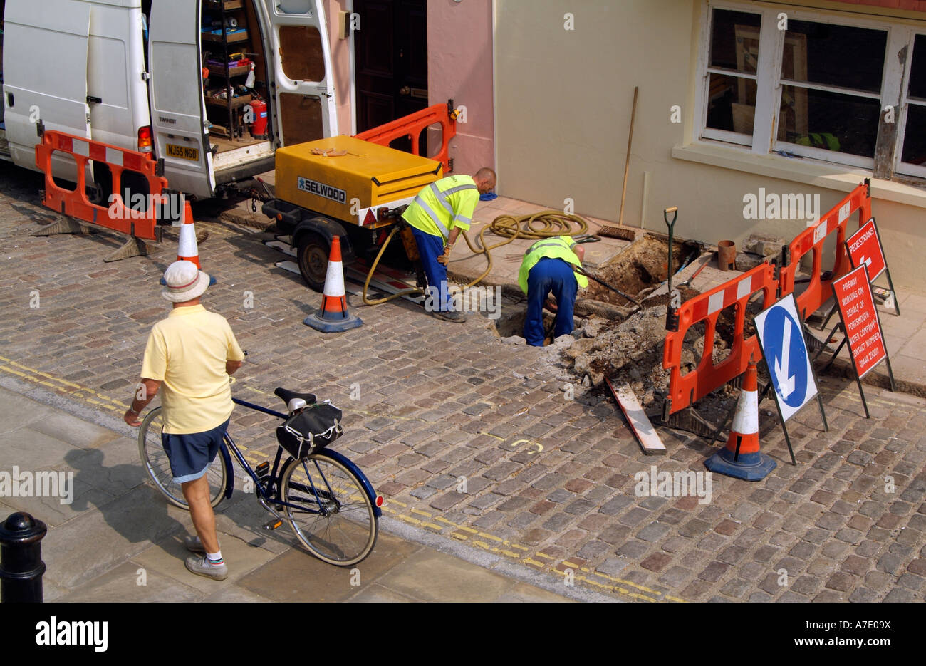 Roadworks Workmen digging a hole in the road England Fixing the water ...