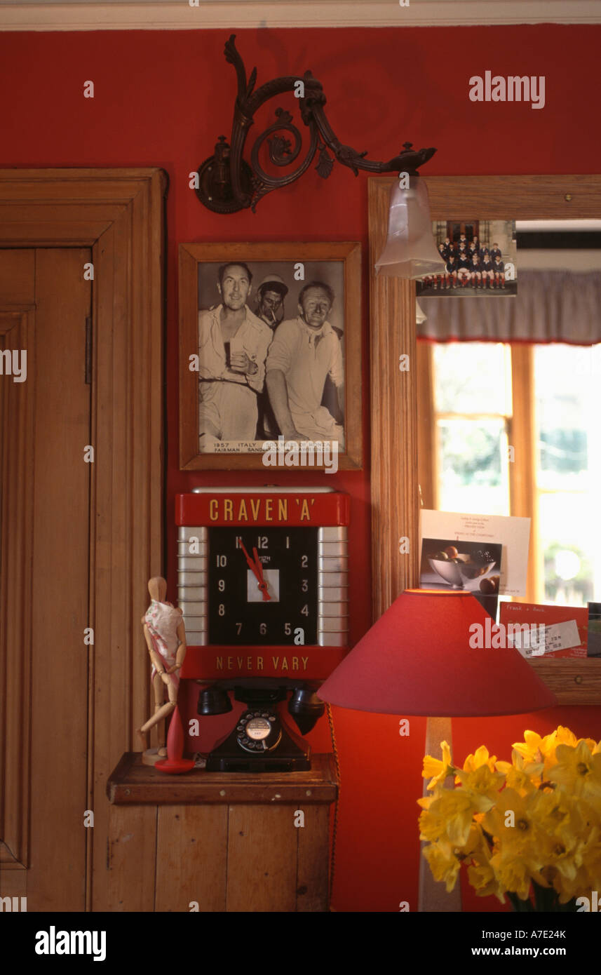 Black+white photograph and Craven A clock on wall in red living room ...