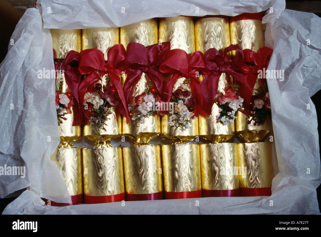 Homemade metallic gold Christmas crackers decorated with red ribbon ...