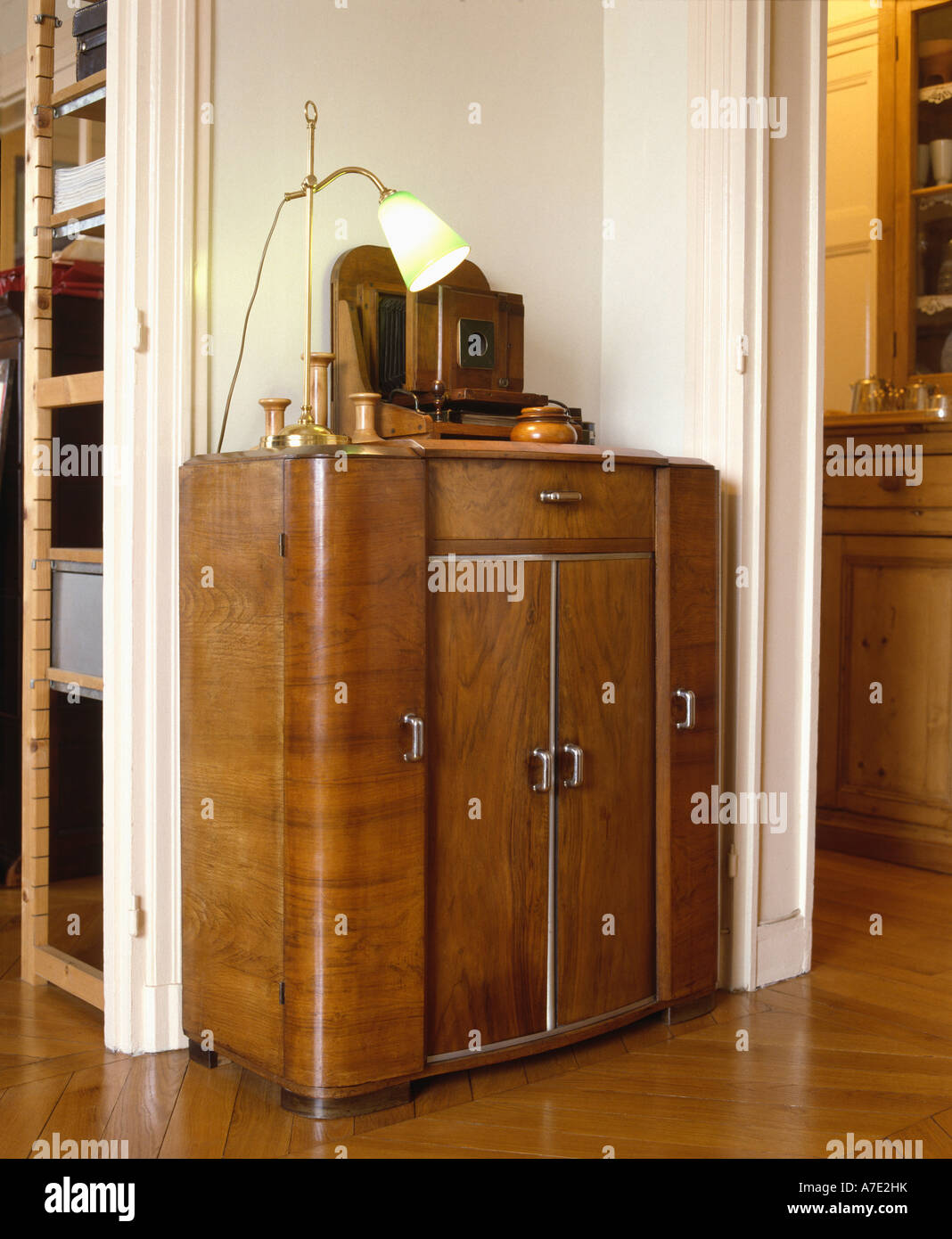 Lamp with glass shade on thirties cupboard with retro camera in ...