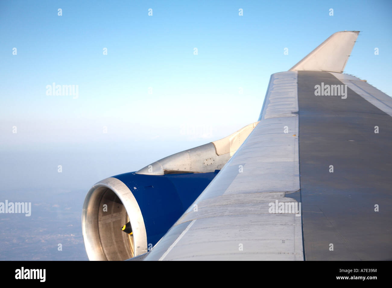 Wing of Being 747 Jumbo Jet with rolls Royce Engines flying with blue ...