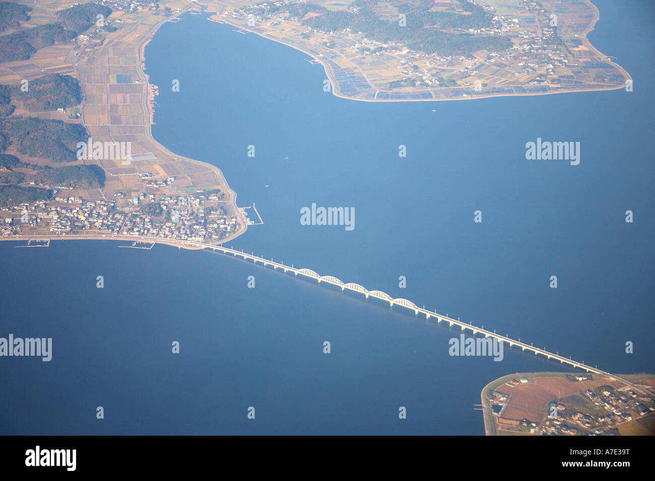 High level oblique aerial view of Japan with long bridge over water ...