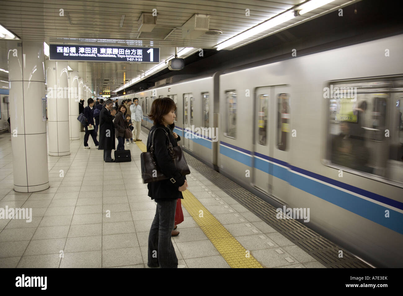Passengers on underground Subway platform at Idabashi in city of Tokyo ...