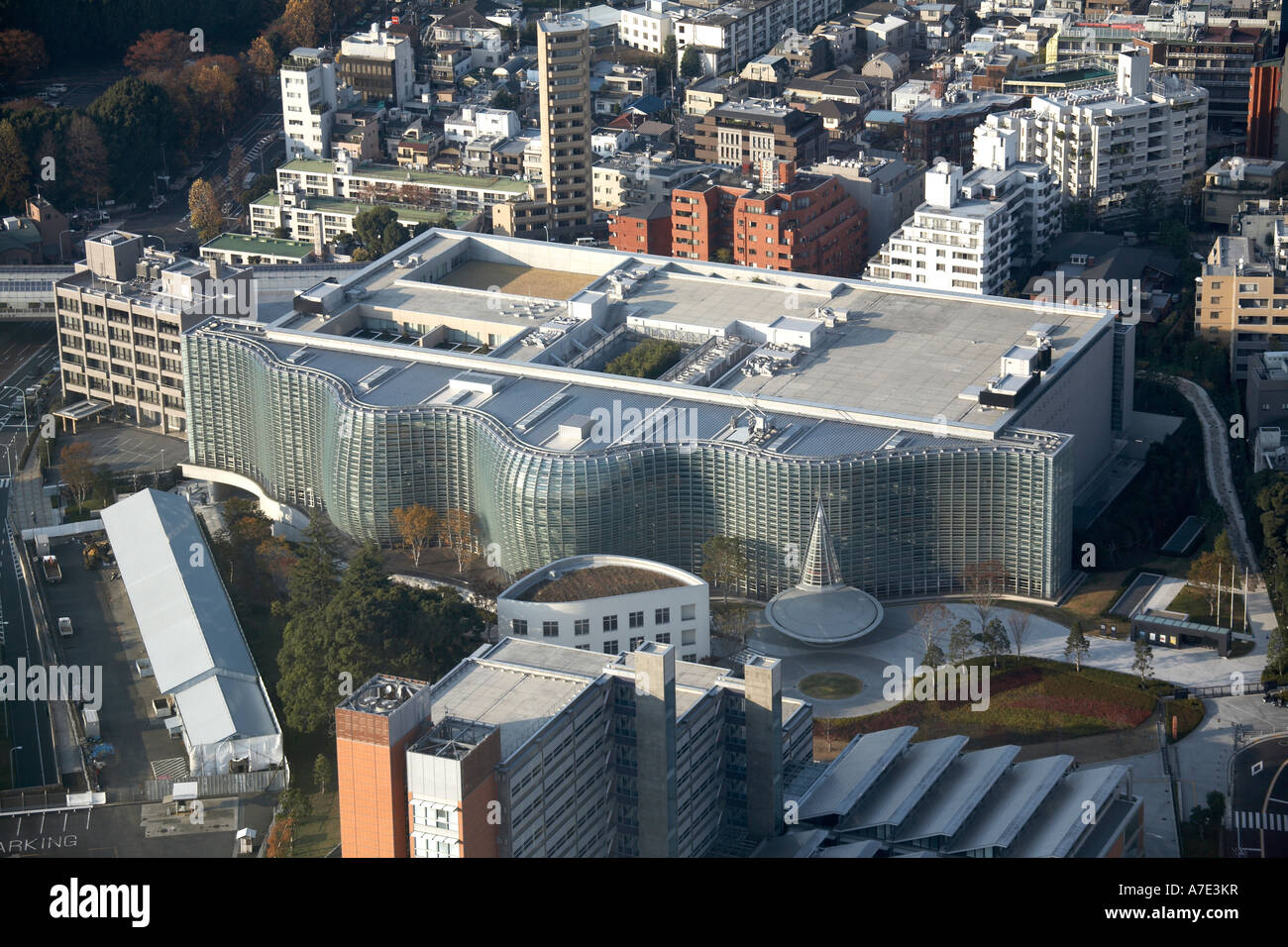 High level oblique aerial view of curved glass fronted office building ...