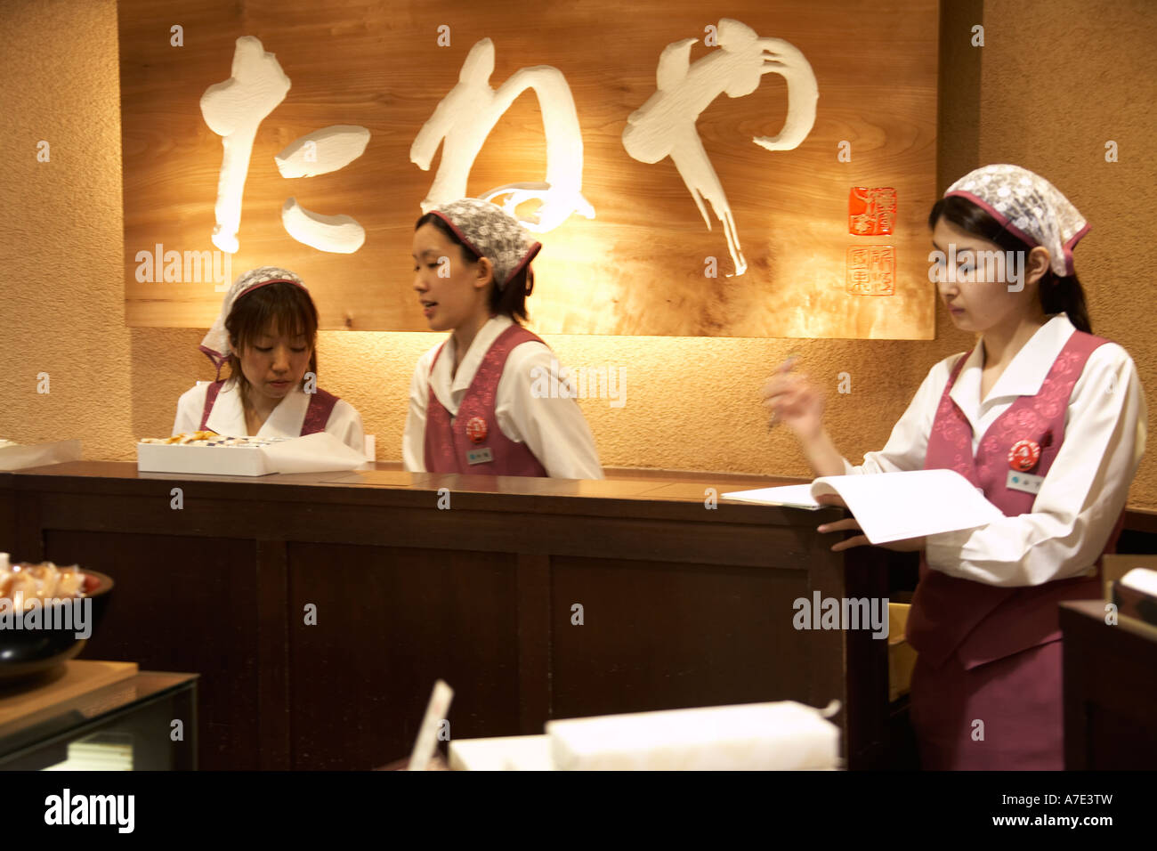 Smartly dressed shop staff in Tokyo Station department store basement ...