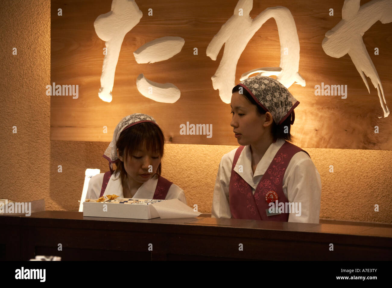 Smartly dressed shop staff in Tokyo Station department store basement ...