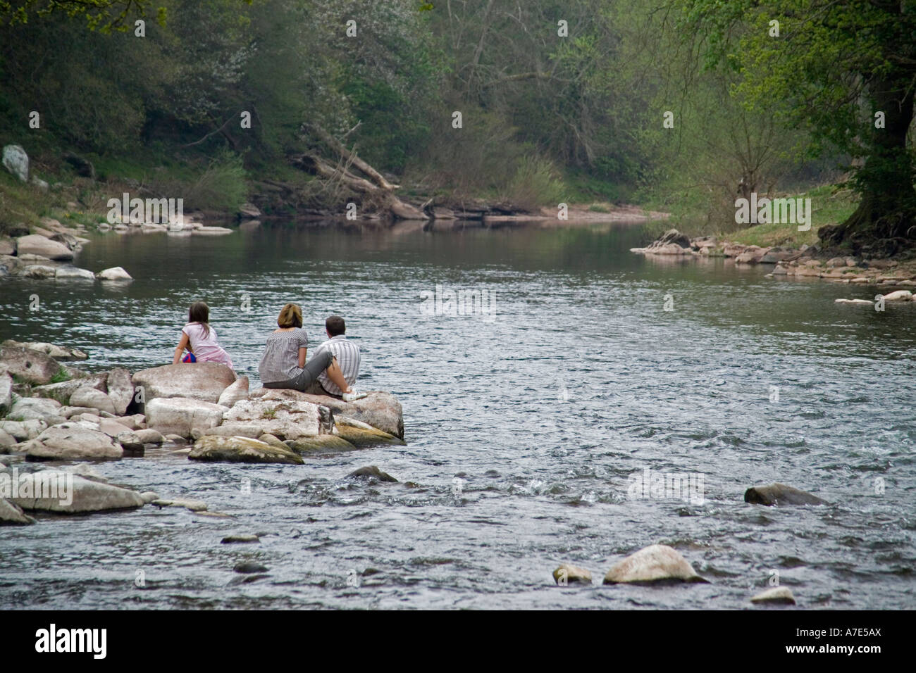 family sitting by the river Stock Photo - Alamy