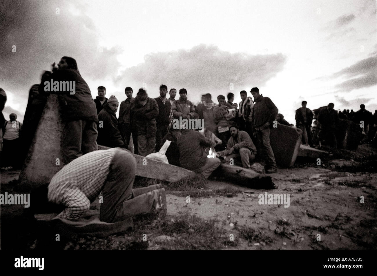 A Palestinian man is praying while queuing following the closure of Abo ...
