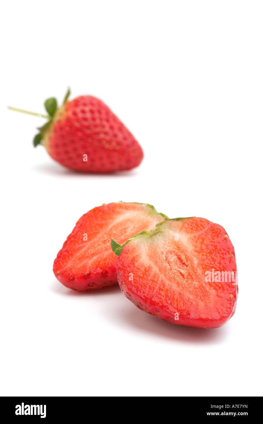 Halved strawberry with whole strawberry in background Stock Photo - Alamy