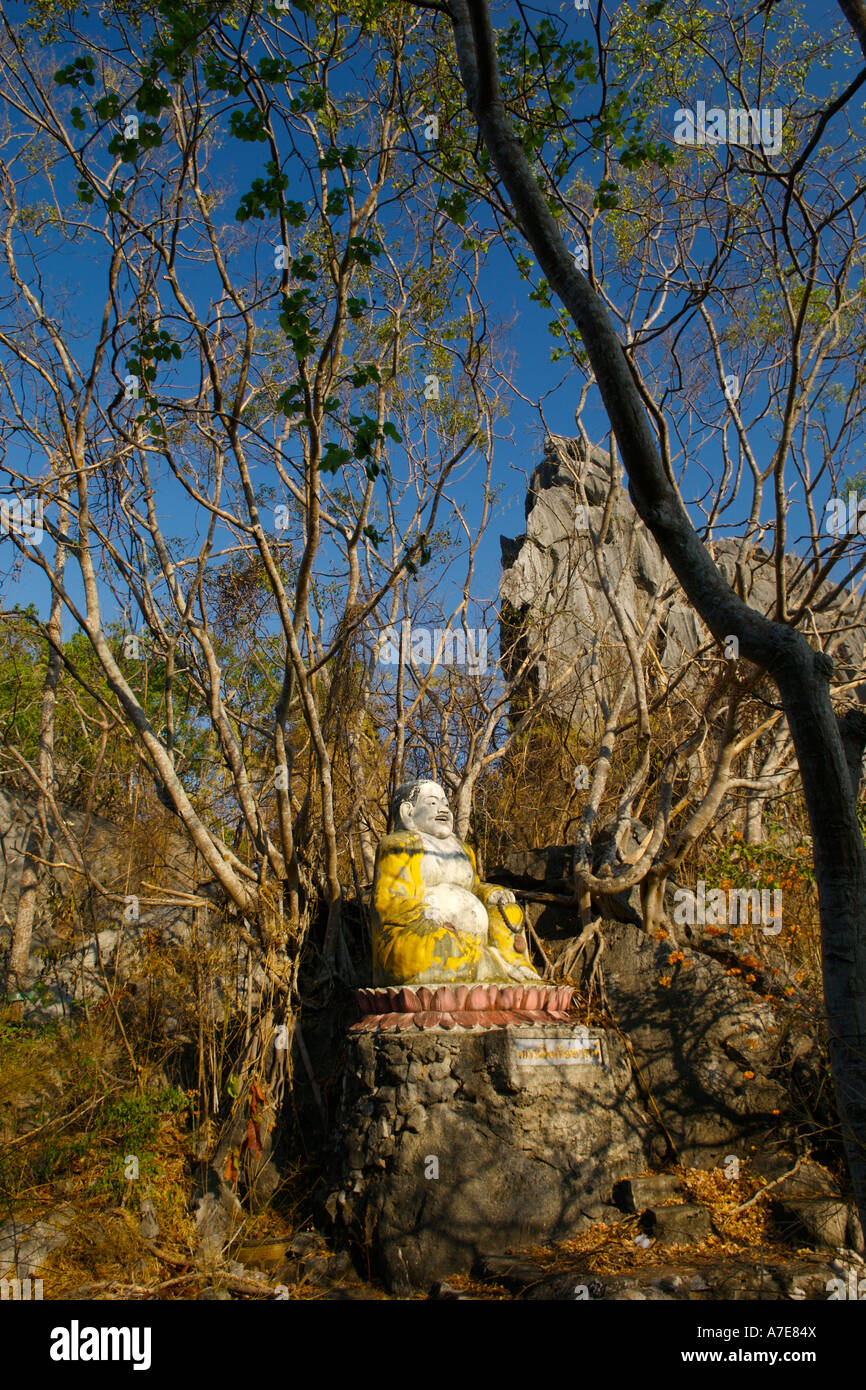 A laughing Buddha statue nestled on top of a mountain pass at Wat Khao ...