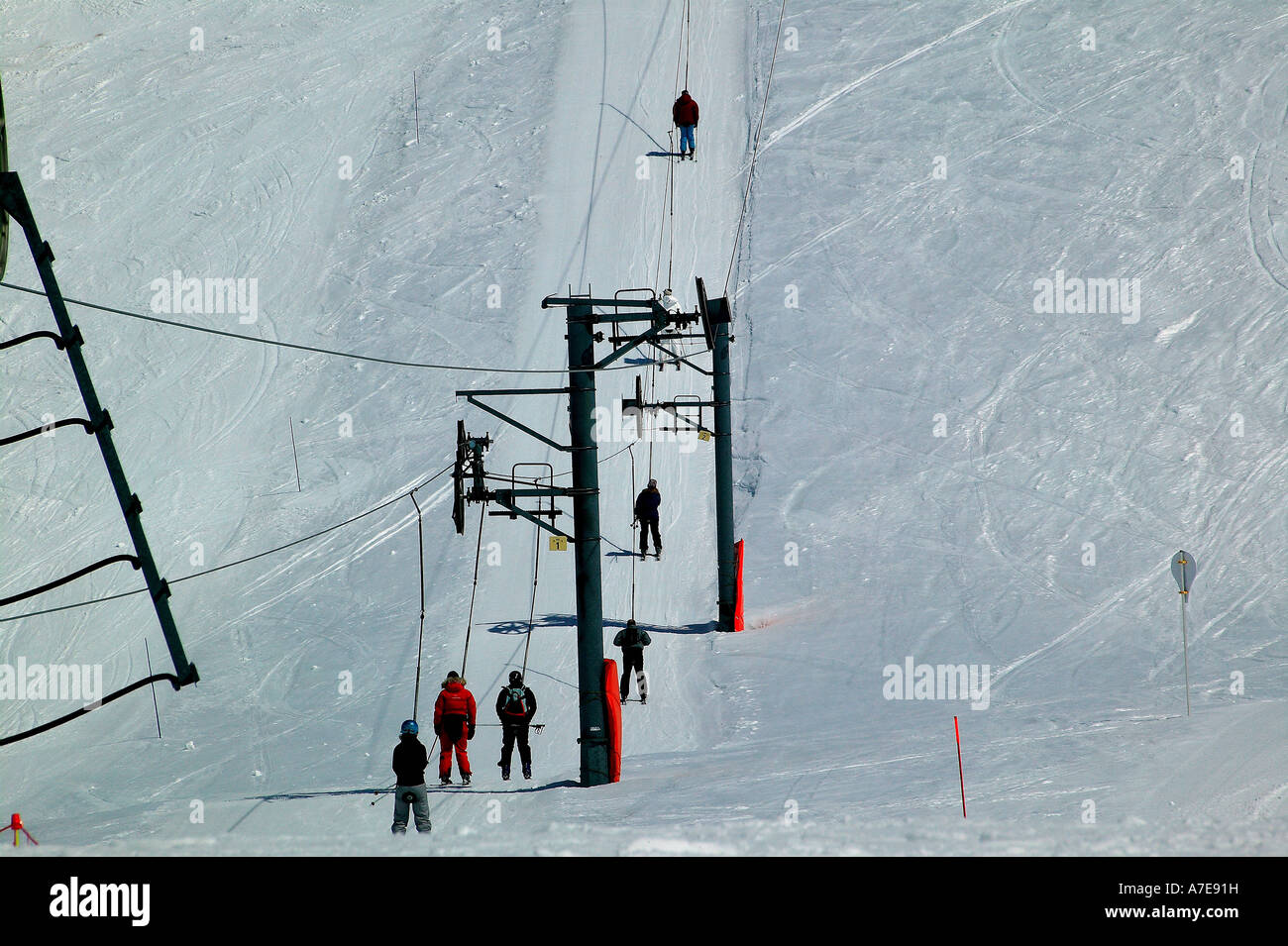 Skiers using a drag lift to ascend the mountain Stock Photo - Alamy