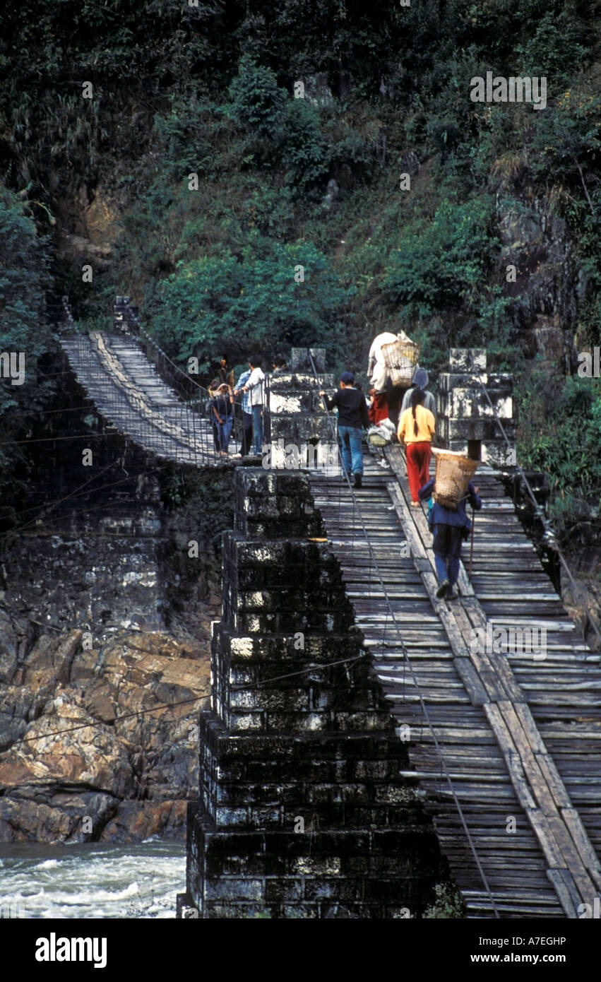 People walking across a suspension bridge over the Salween river in ...