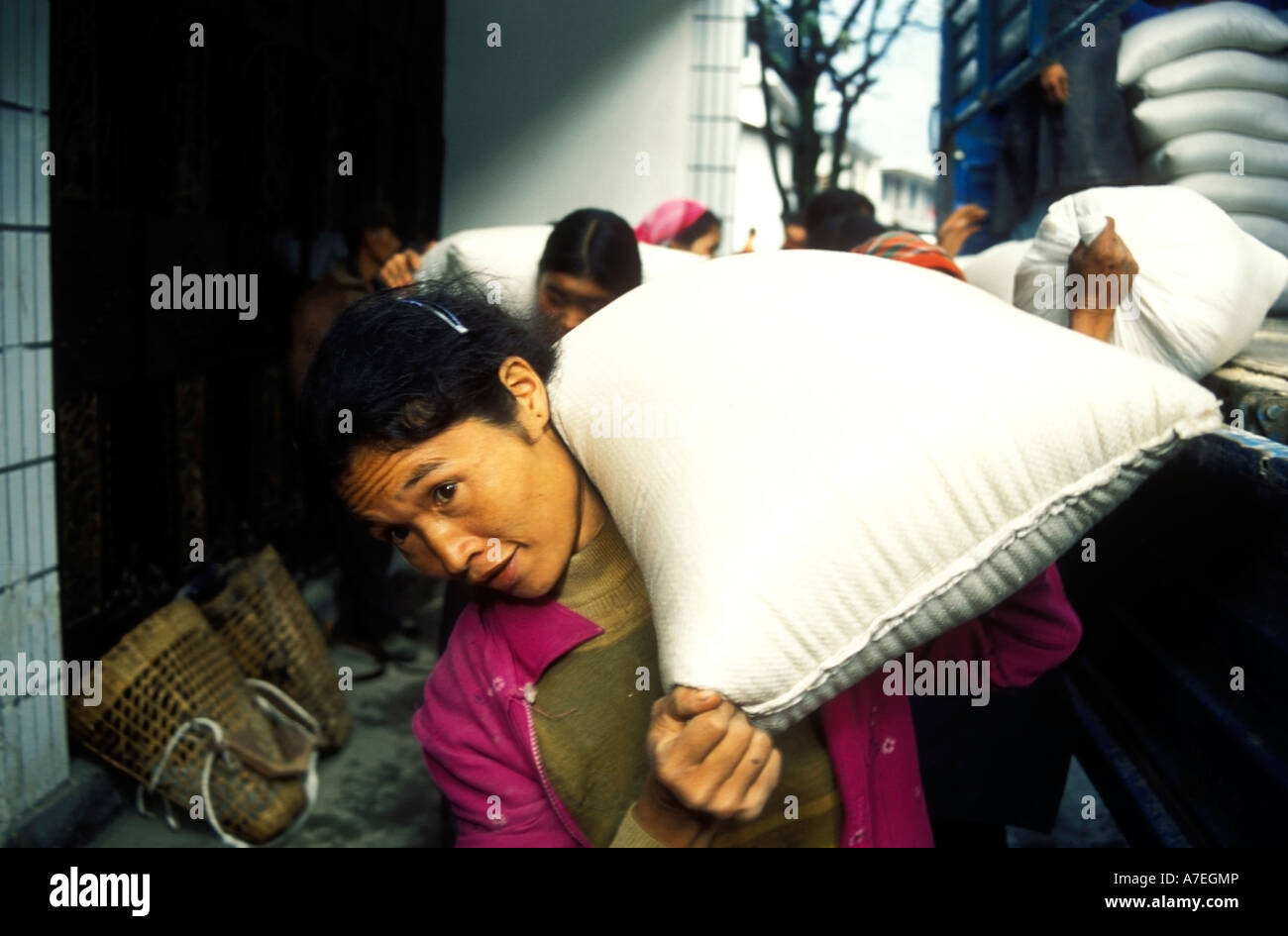 Woman unloading a sack of rice from a truck Stock Photo - Alamy