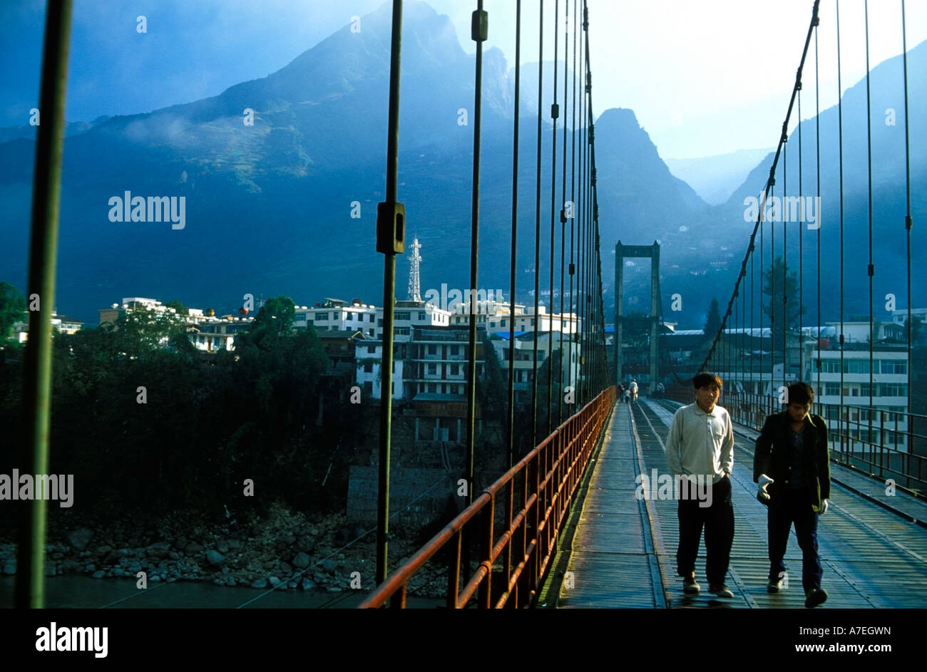 Two people crossing a suspension bridge over the Salween river in ...
