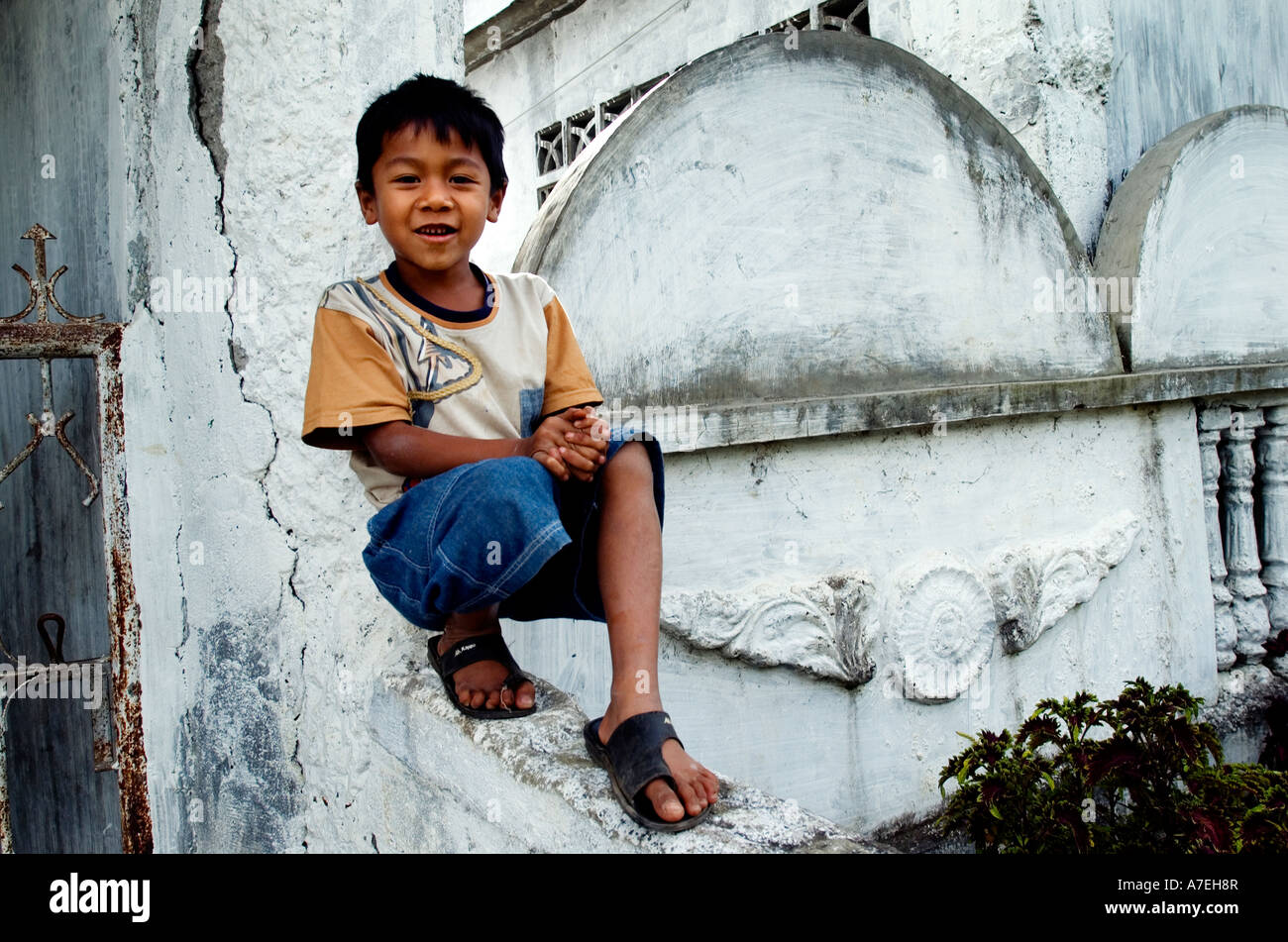 Boy sitting on a white washed fence Stock Photo - Alamy