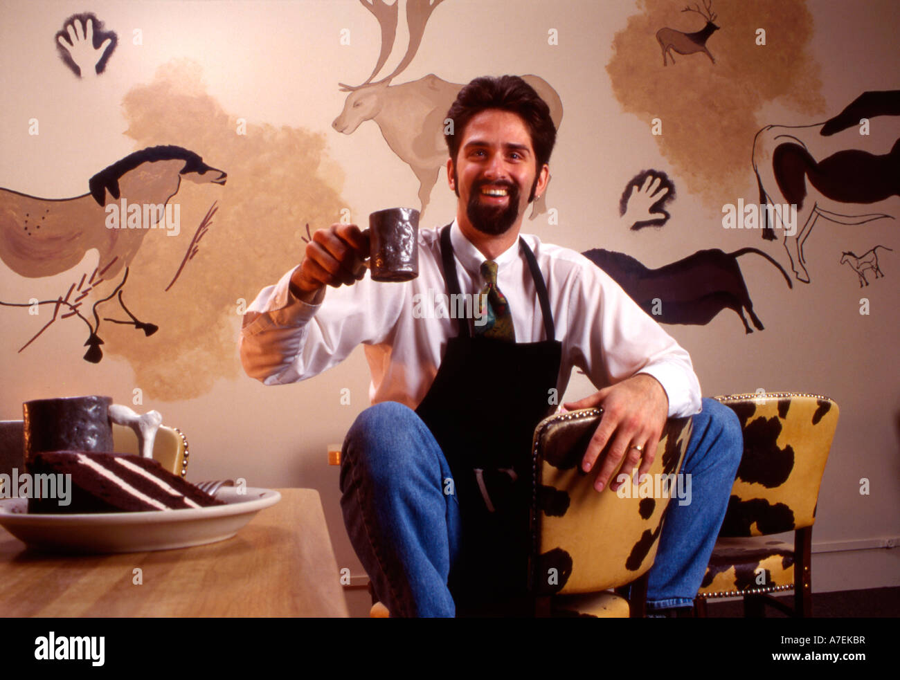 Coffee shop owner holding coffee cup Stock Photo - Alamy