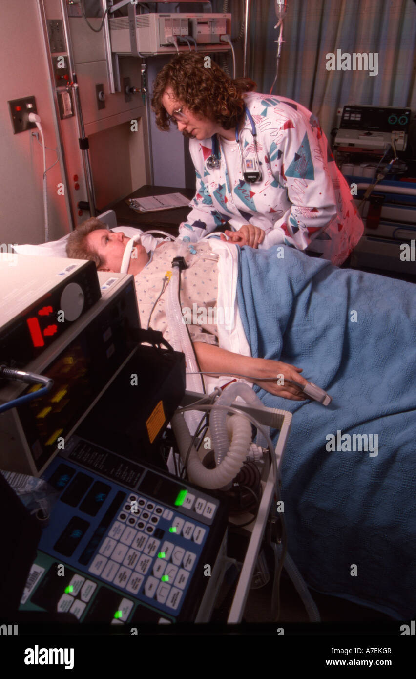 Nurse tends to patient on ventilator in hospital bed Stock Photo - Alamy