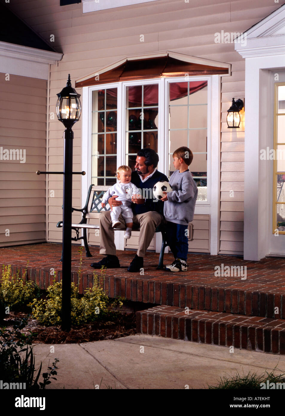 Father with son and baby sitting on porch at night Stock Photo - Alamy