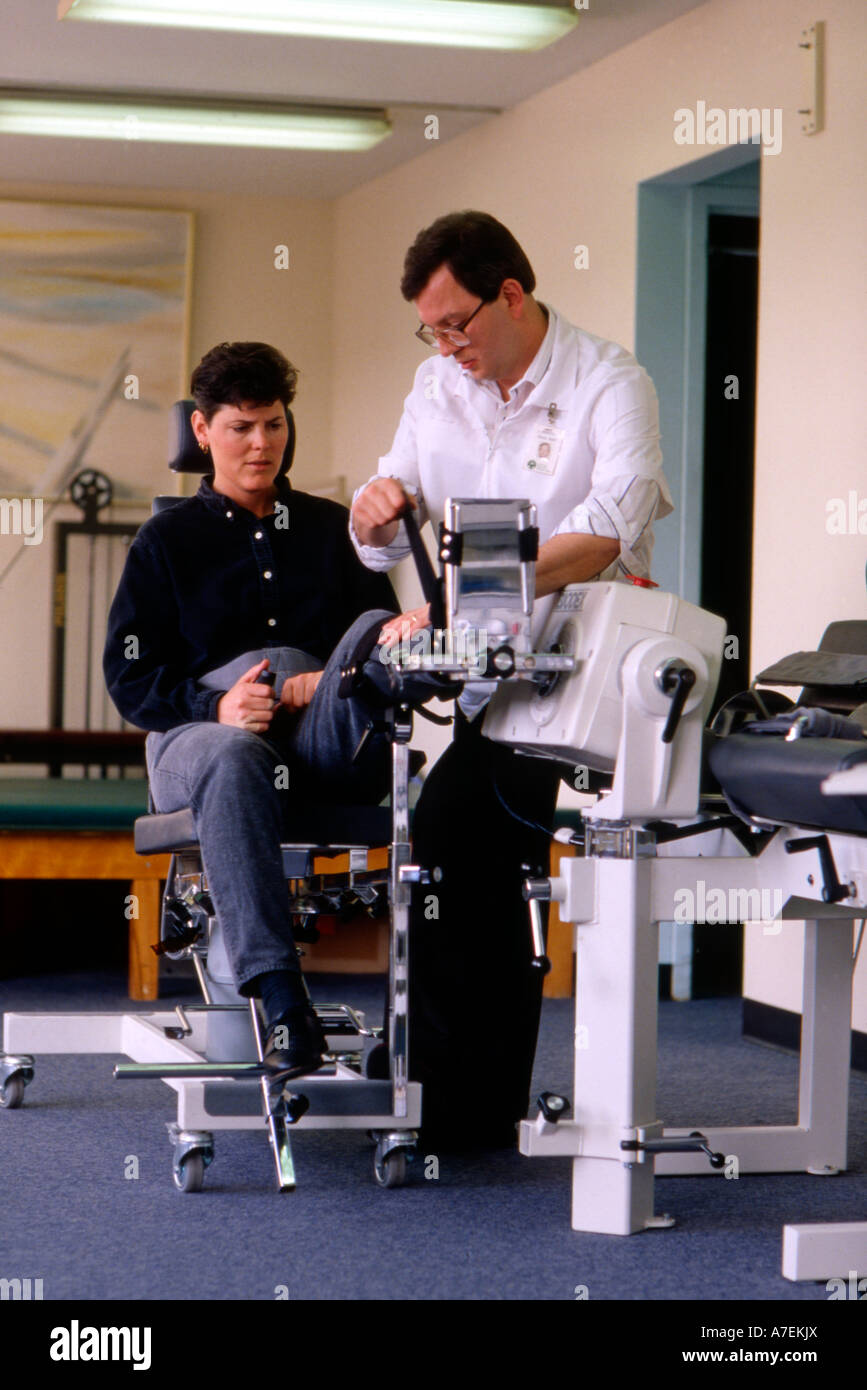 Physical therapist adjusts woman s leg in range of motion machine Stock ...