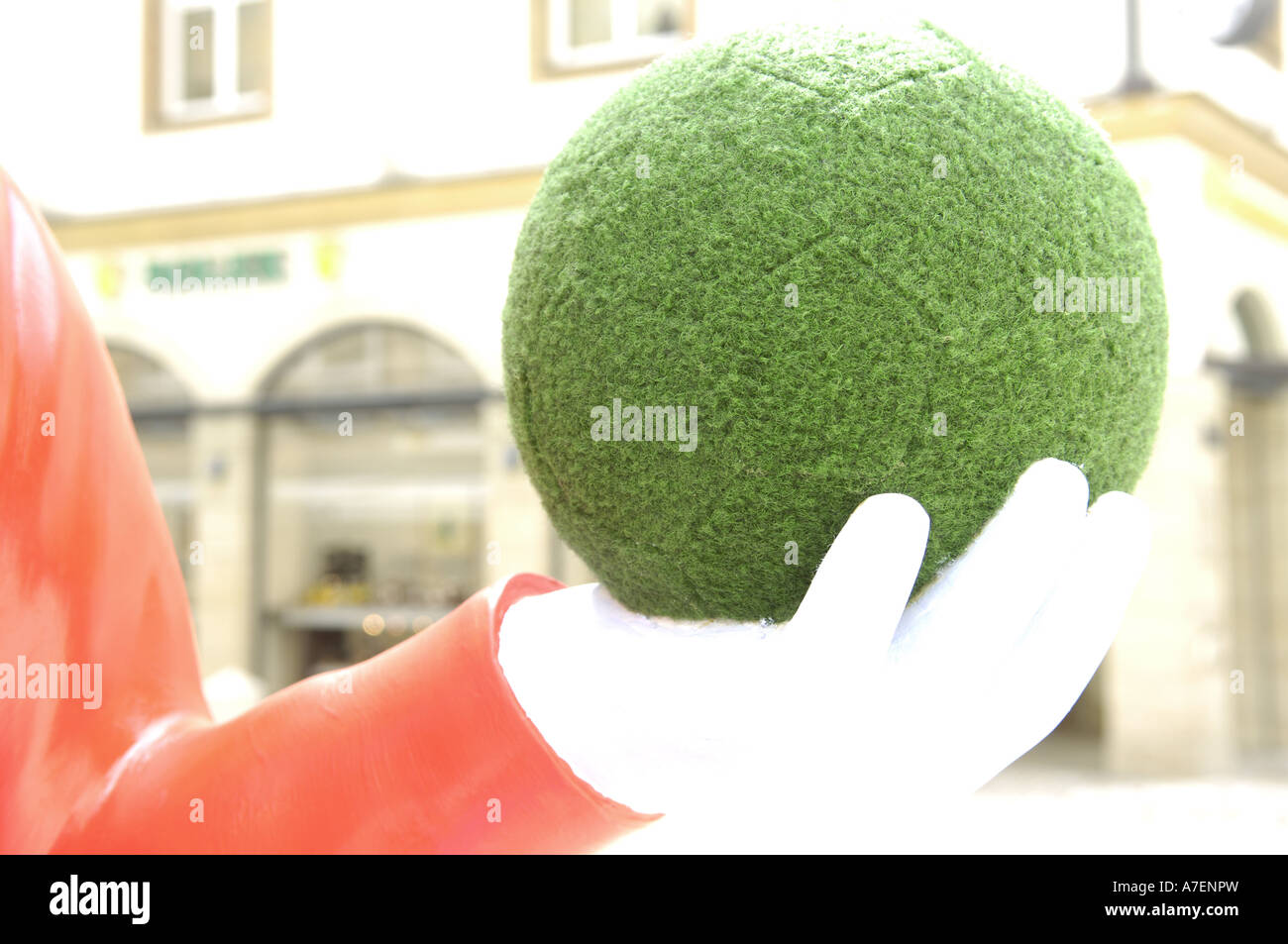statue hand hold football grass green natural red horizontal ball Stock ...
