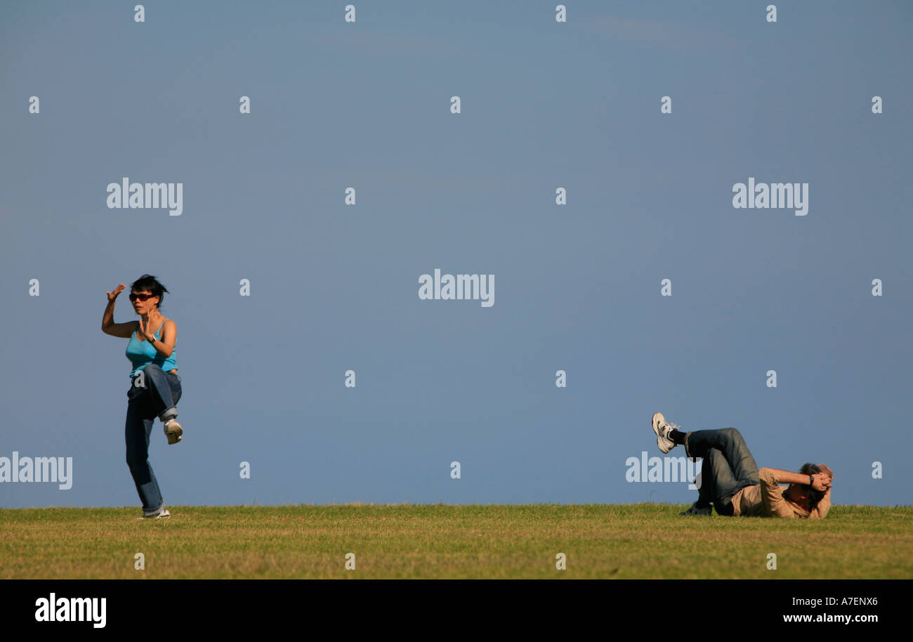 A woman practise the ancient chinese art of Tai Chi whilst her partner ...