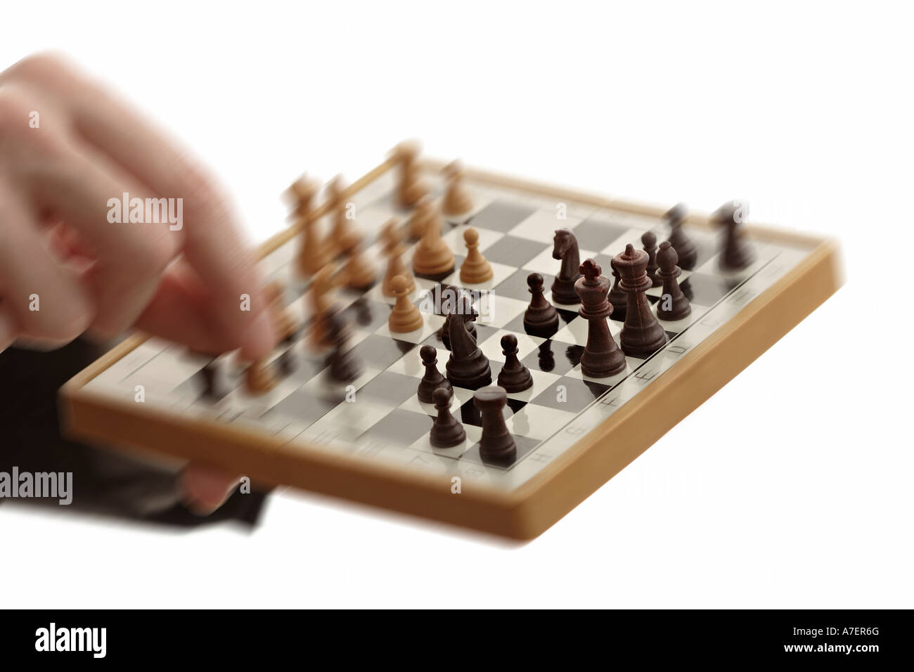 Hand moving pawn figure on portable chessboard, white background, blur ...