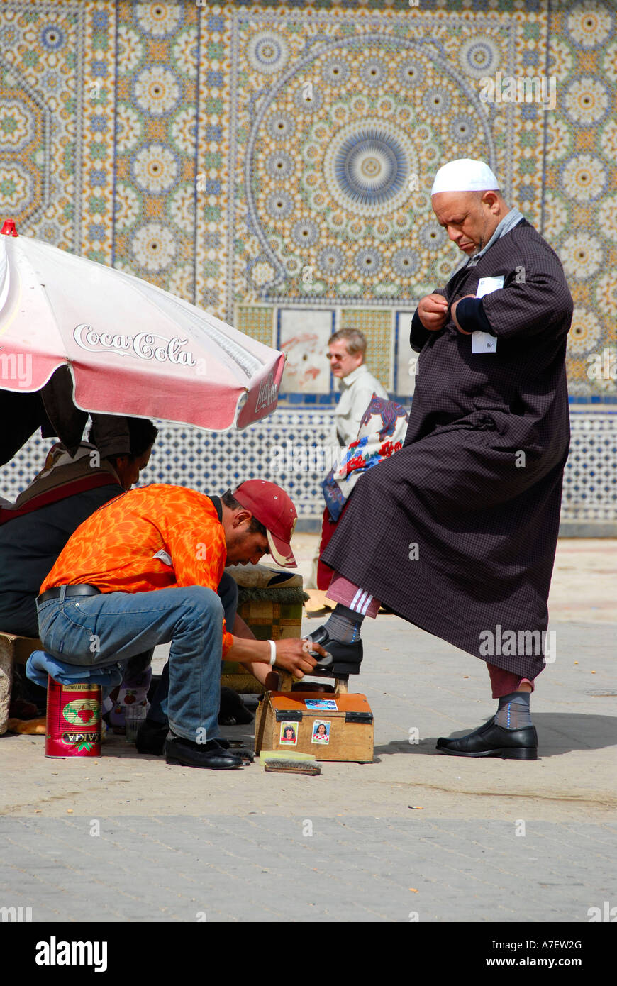 Traditionally dressed man in jelaba gets shoe shine service Place el ...