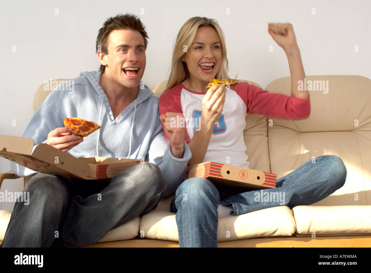 Couple watching tv while eating pizza hi-res stock photography and ...