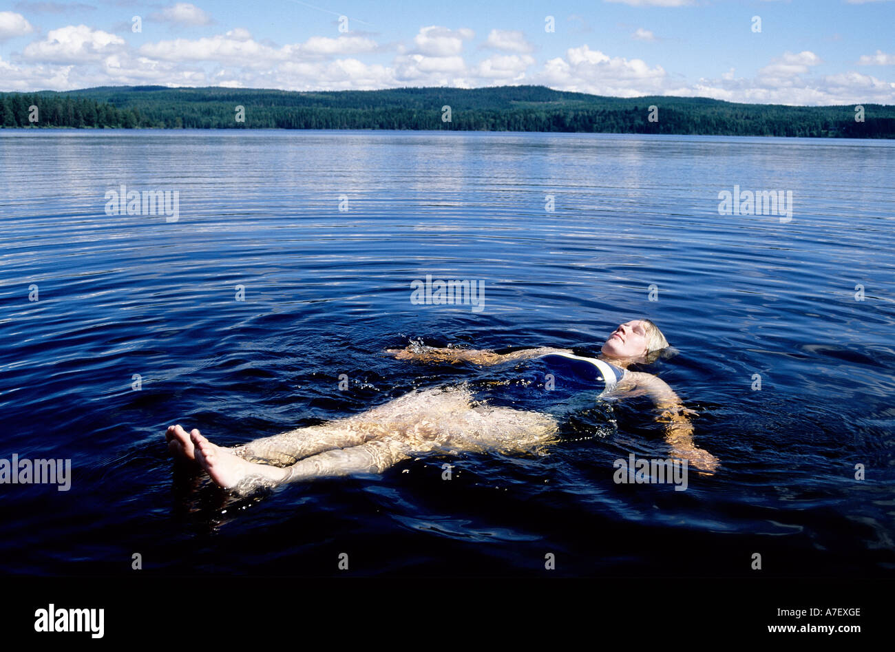 Woman floating in water Stock Photo - Alamy