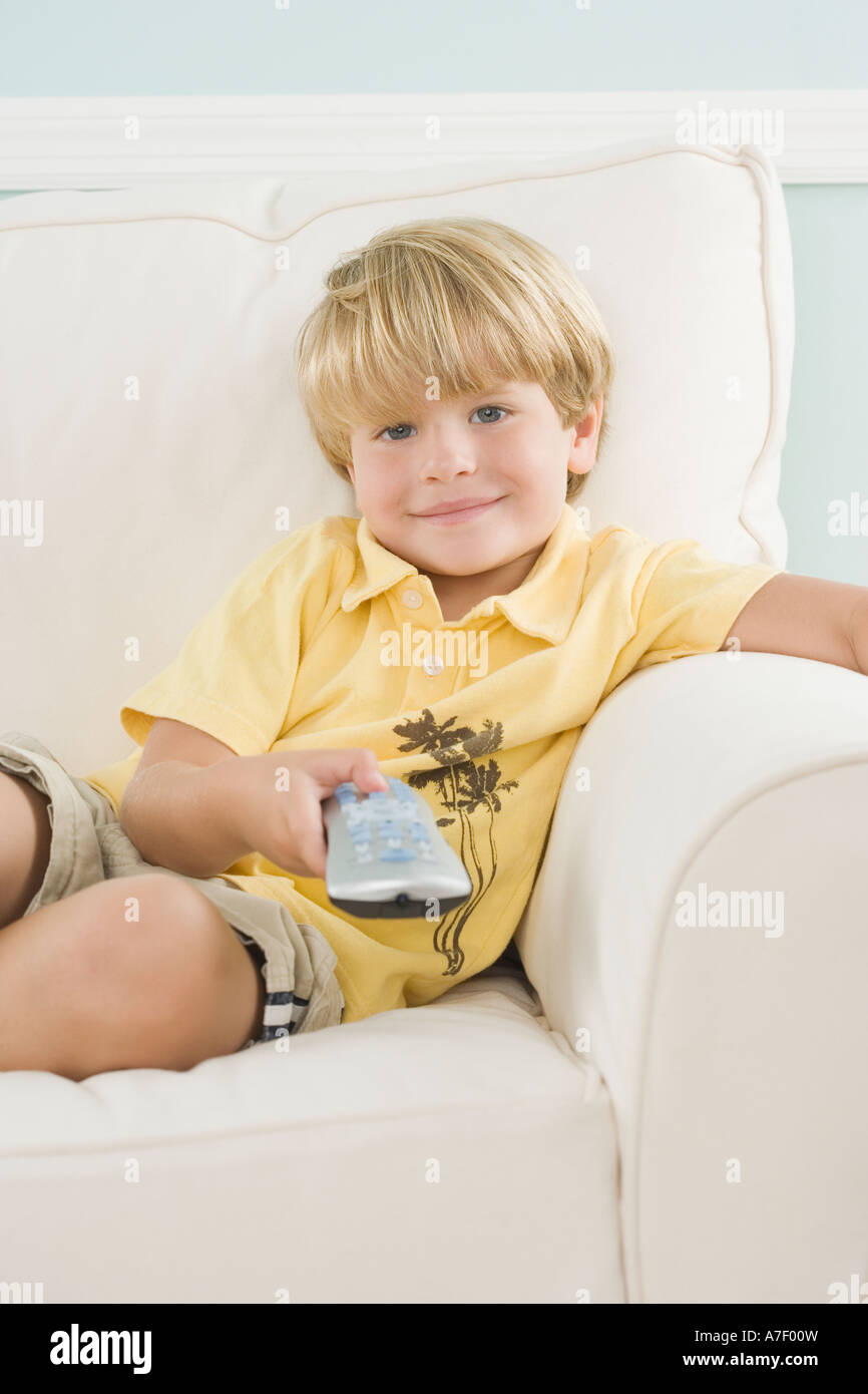Young boy on sofa pointing remote control Stock Photo - Alamy