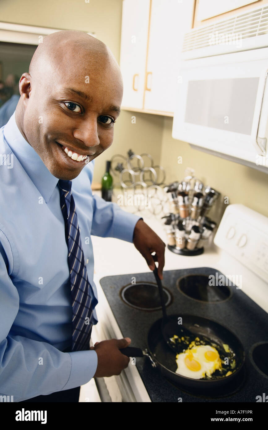 African man cooking eggs in kitchen Stock Photo - Alamy
