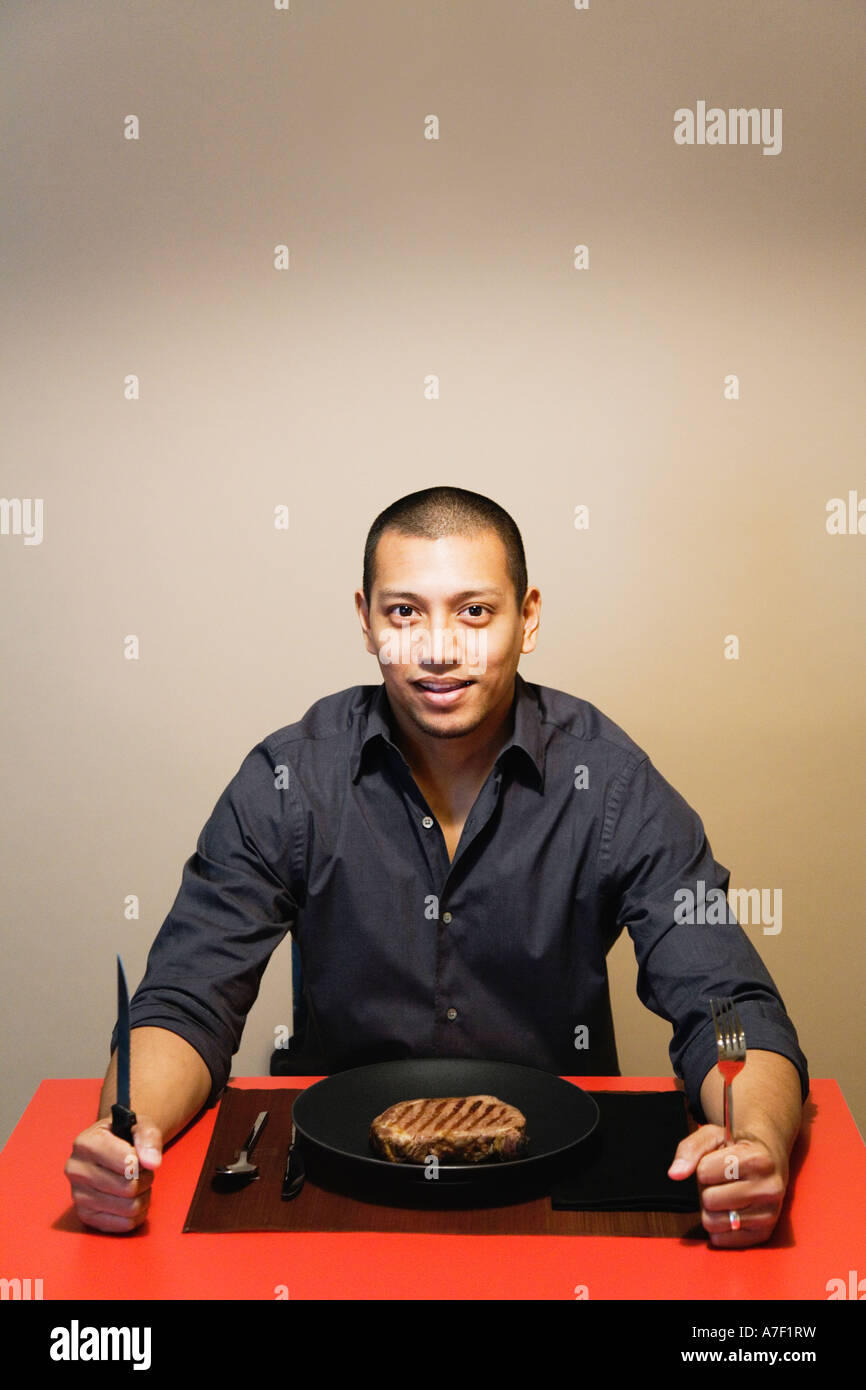 Asian man at dinner table with steak Stock Photo - Alamy