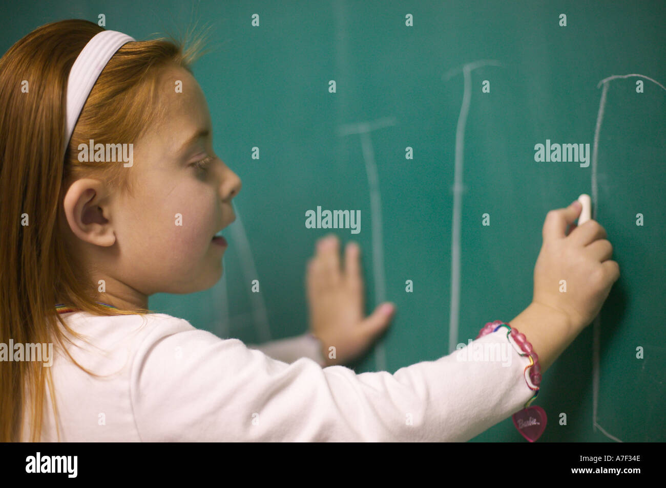 Four Year Old Girl Writing On Chalkboard In School Classroom Stock ...