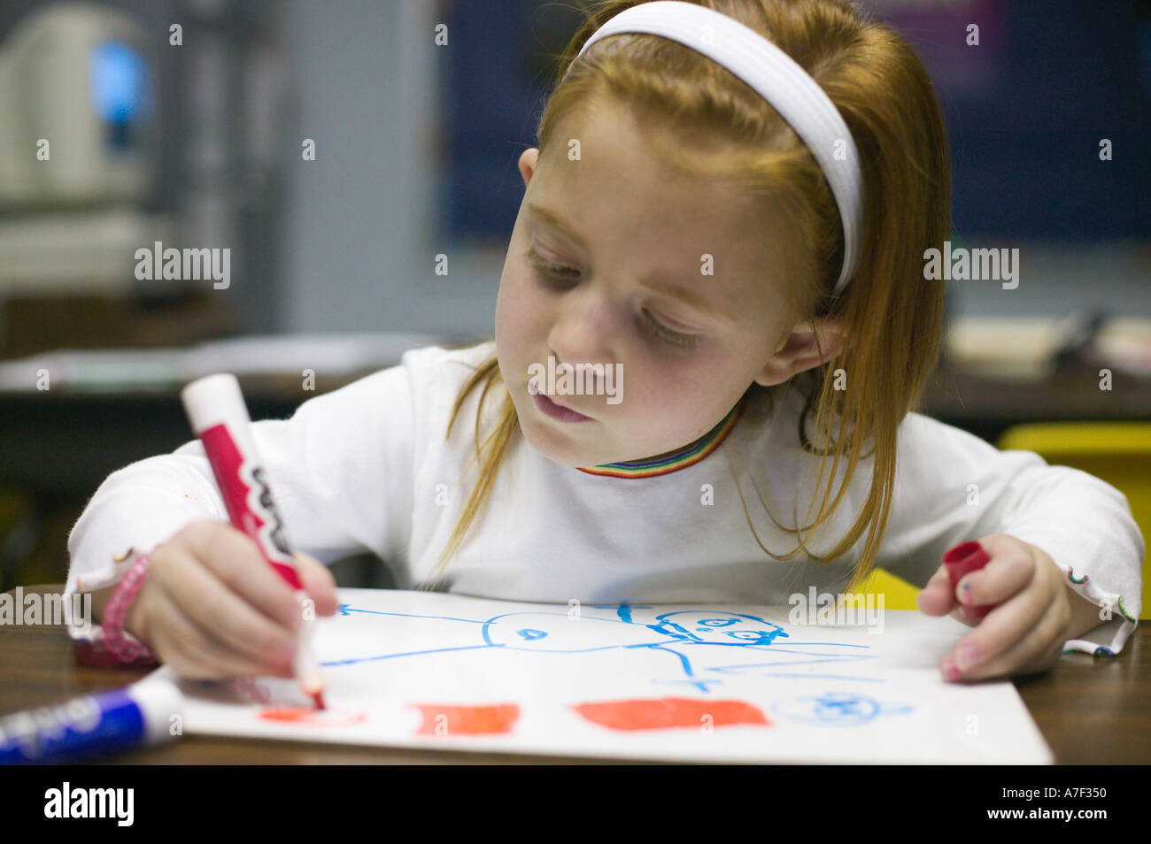 Four Year Old Girl Doing Writing Assignment In School Classroom Stock ...