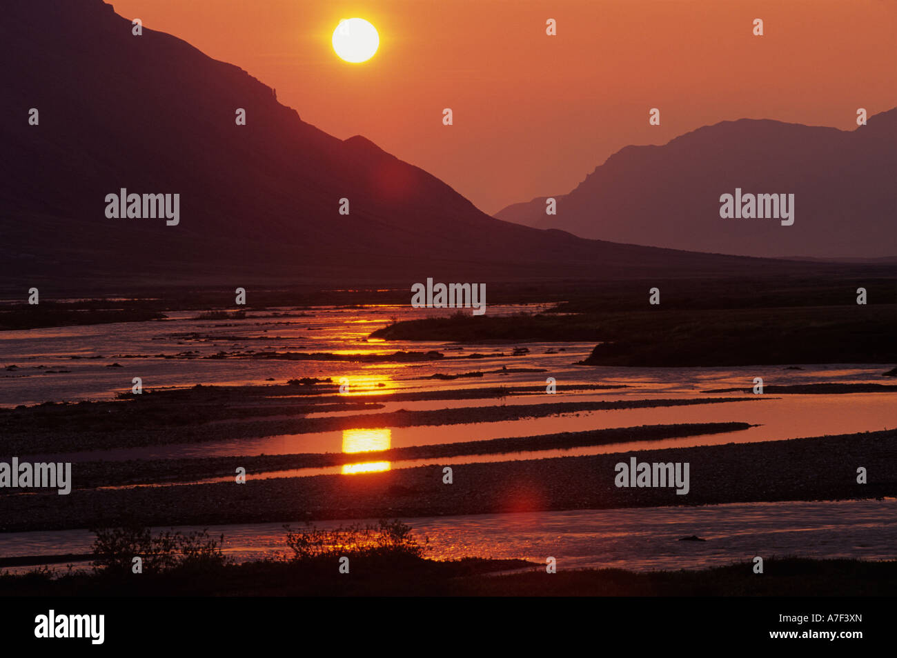 USA Alaska Setting midnight sun reflects off Atigun River in Brooks ...
