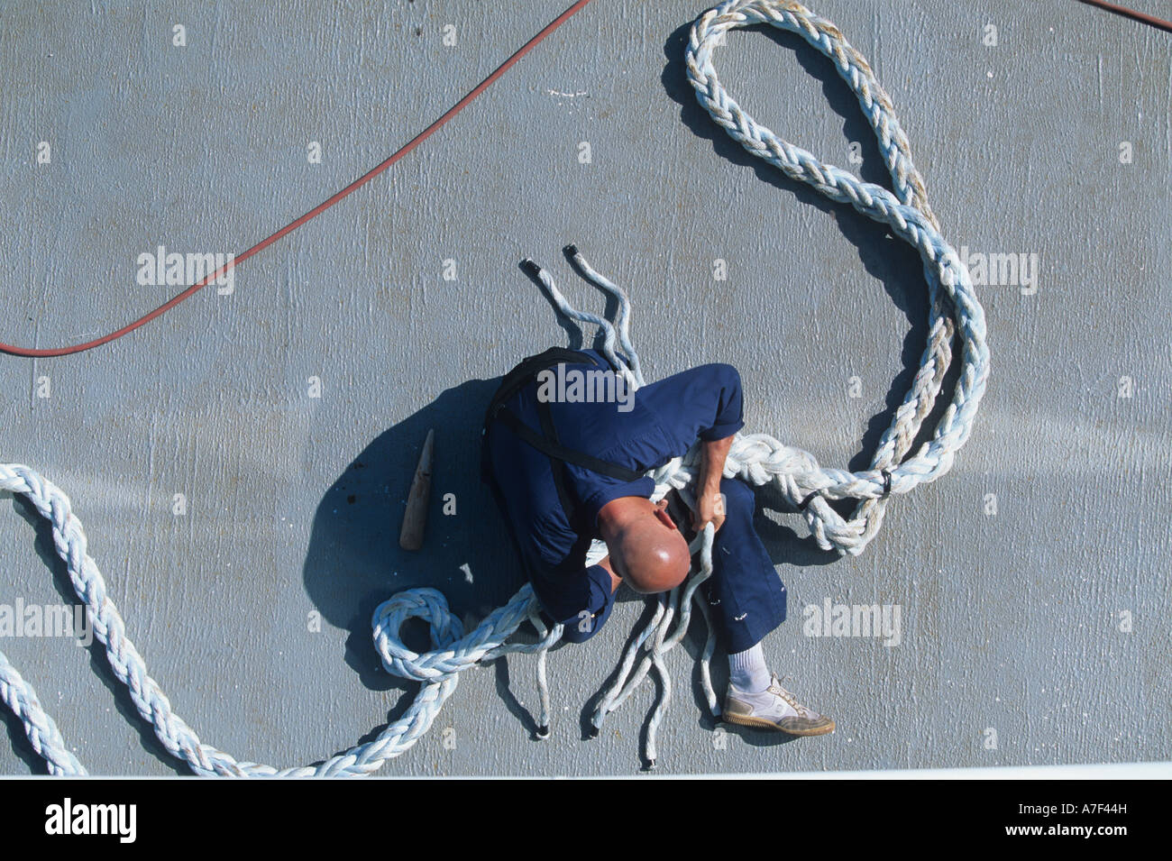 USA, Alaska, (MR) Jim Brackett works on ship's lines aboard Ferry M/V ...