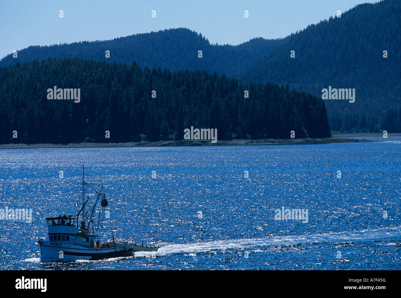 USA Alaska Fishing boat sails along Inside Passage in summer sunshine ...
