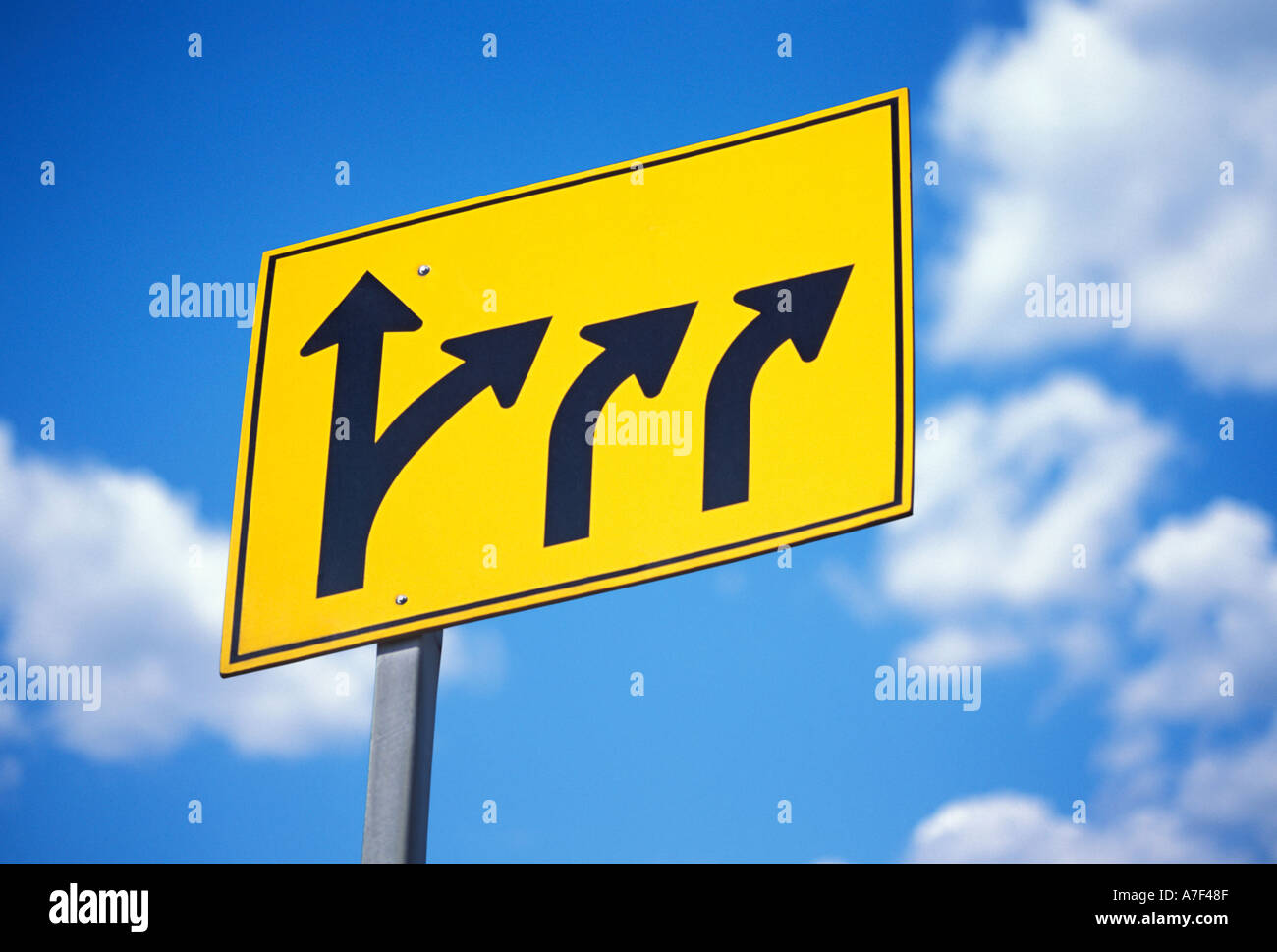 Large yellow sign with directional arrows pointing in multiple ...