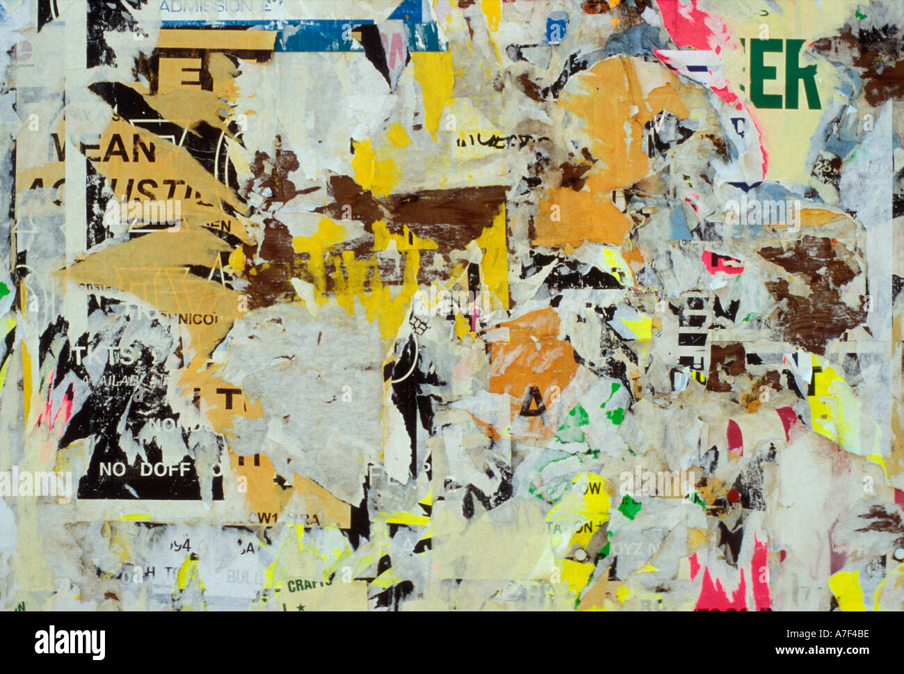 Wall covered with multi-colored pieces of torn paper remnants from ...