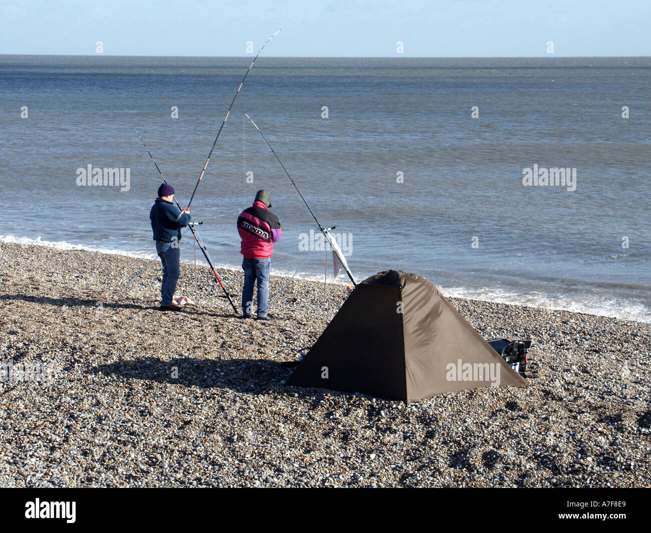 Aldeburgh pebble and shingle beach back view two men standing sea ...