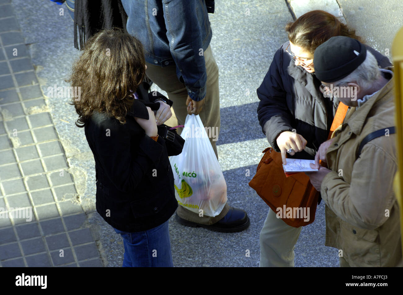 lost map reading three people visitors travellers tourists pavement ...