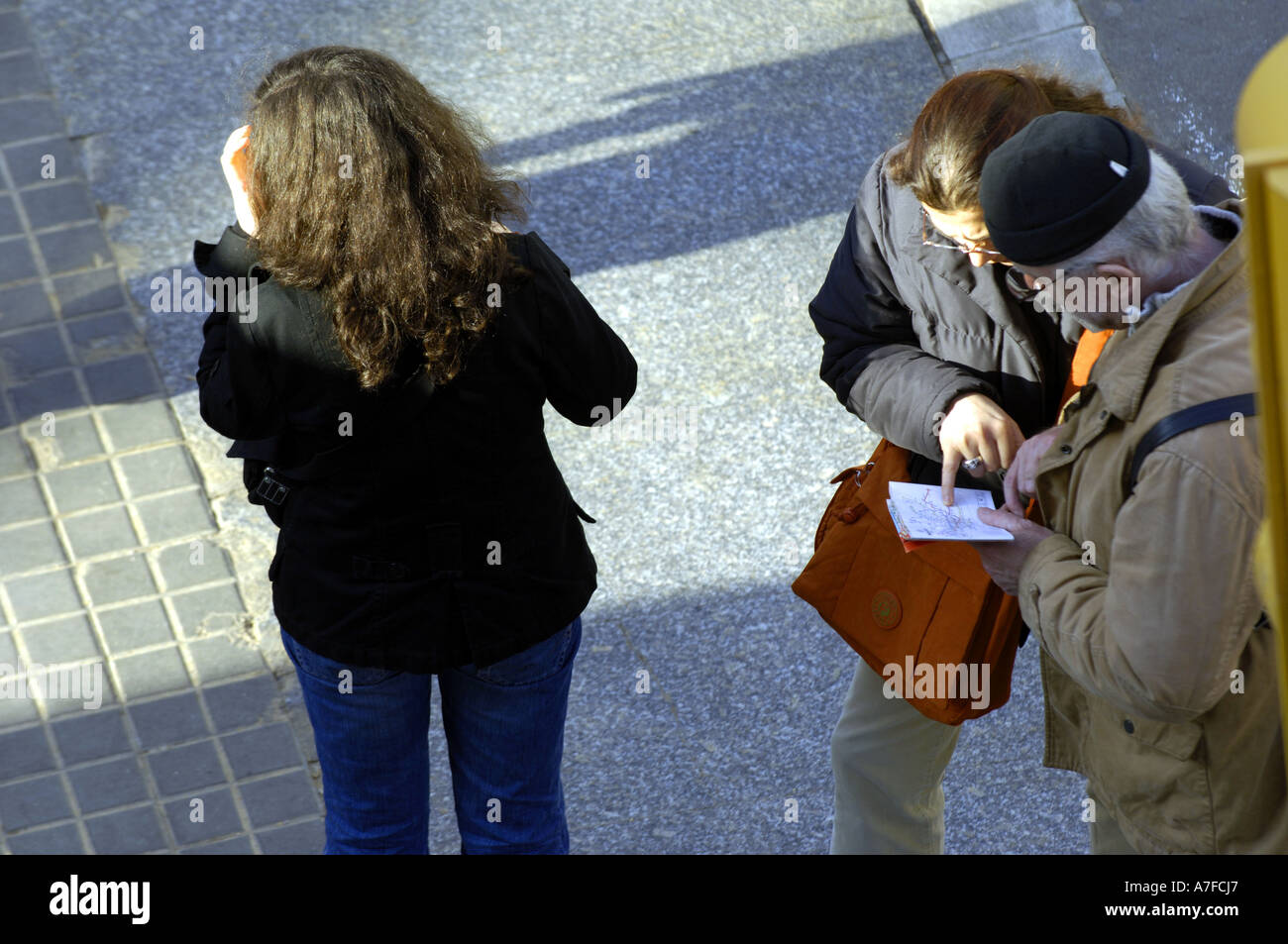 lost map reading three people visitors travellers tourists pavement ...