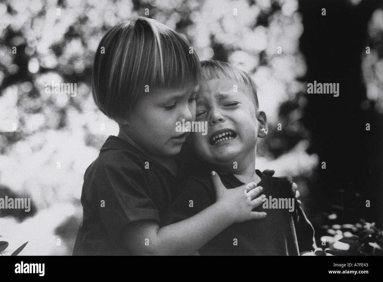 Big sister comforts and embraces her little brother to alleviate Stock ...