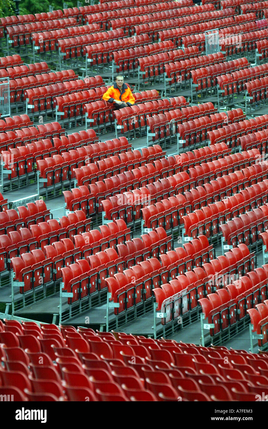 A man sits in a empty stand built for an outdoor concert in Bath , 2003 ...