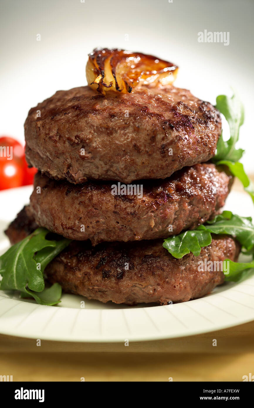 Three Quarter Pounder burgers in a tower with rocket and tomato Stock ...