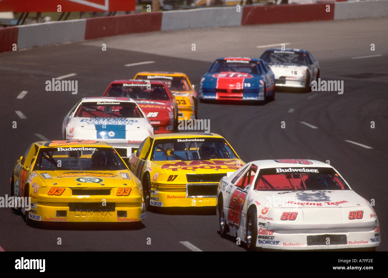 Multi colored race cars circling on a race track Stock Photo - Alamy