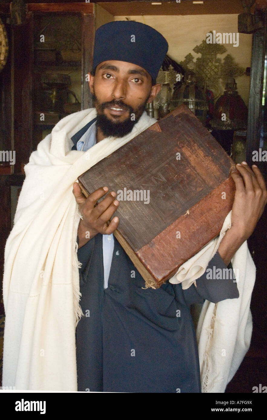 Monk holding a bible in a monastery museum on Zege Peninsula, Lake Tana ...